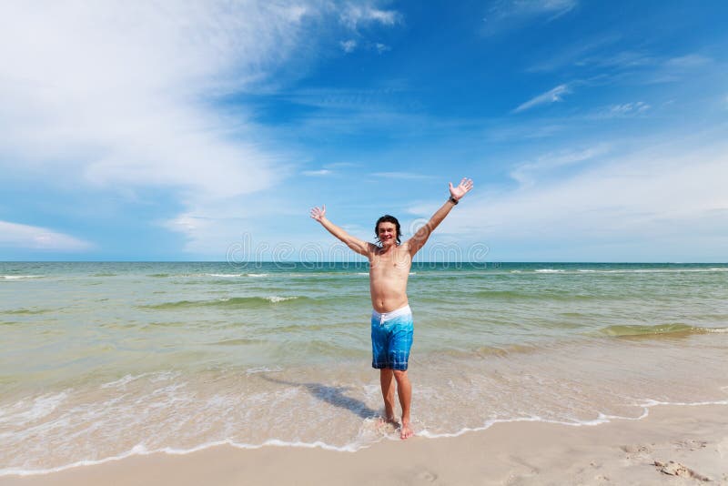 Ein Junger Mann, Der Auf Einem Sandigen Strand Steht. Stockfoto - Bild ...