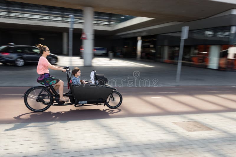 Eine Frau, Die Mit Kindern Auf Einem Frachtfahrrad am Zentralen Bahnhof ... Eine Frau, Die Mit Kindern Auf Einem Frachtfahrrad am Zentralen Bahnhof ...
