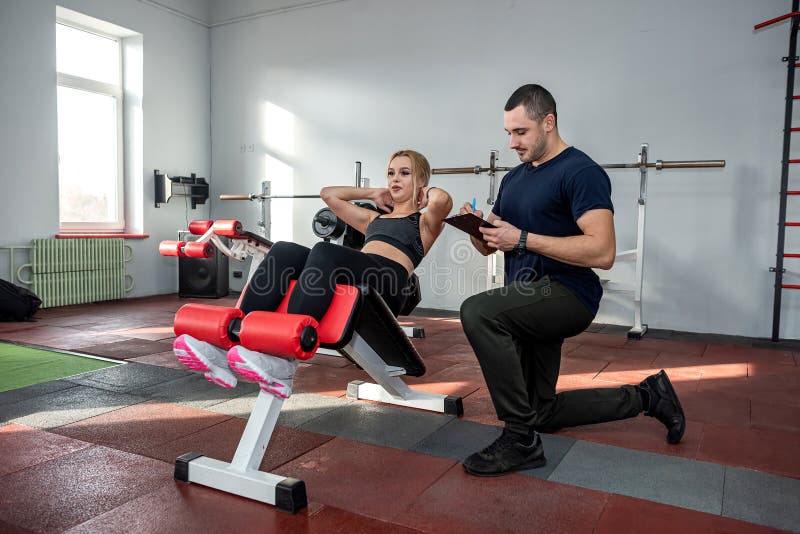 El Entrenador Se Encarga De Los Clientes Del Gimnasio Foto de archivo ... El Entrenador Se Encarga De Los Clientes Del Gimnasio Foto de archivo ...