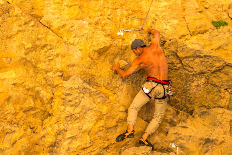 El Escalador De Roca Escala Una Pared Vertical Imagen de archivo ...