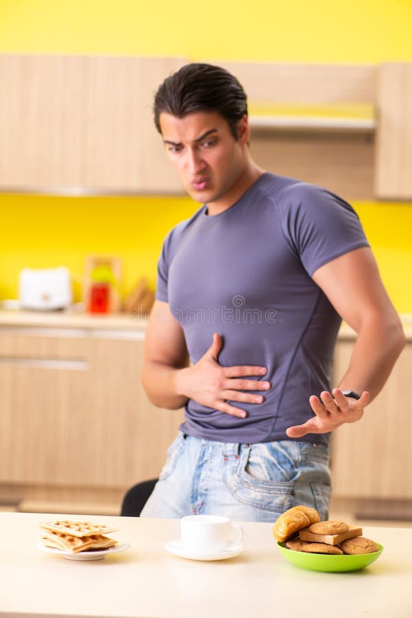 El Hombre Joven En Concepto Malsano De La Comida Foto de archivo ...