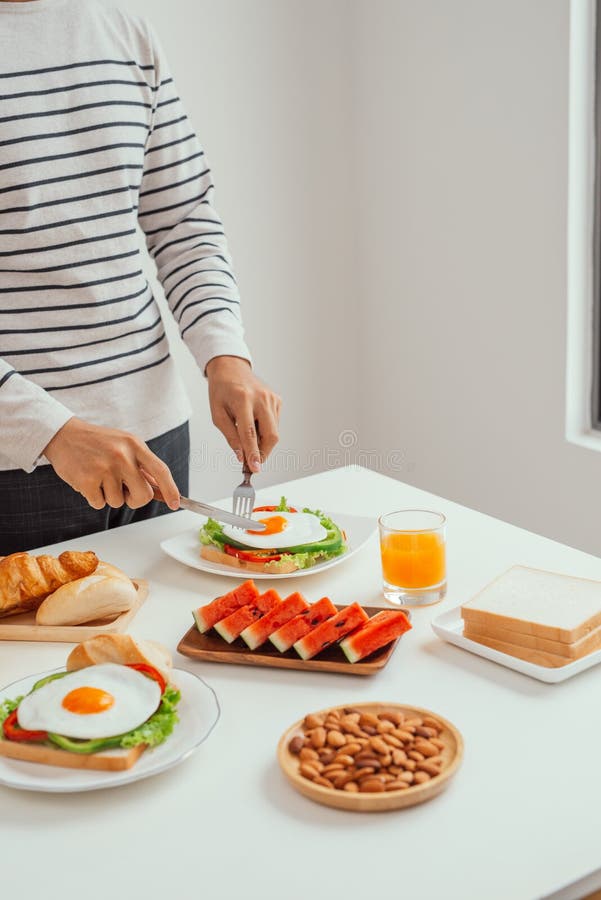 El Joven Desayuna Con Cuchillo Y Tenedor Imagen de archivo - Imagen de ...