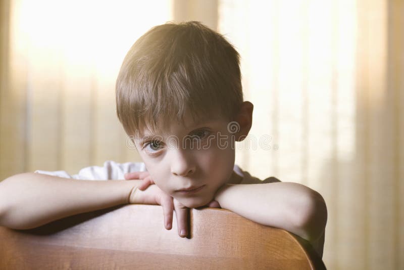 El Muchacho Que Se Inclina Encendido Apoya De Silla Foto de archivo ...