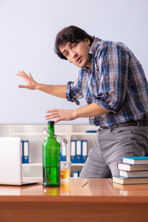 El Profesor De Sexo Masculino Que Bebe En La Sala De Clase Foto De Archivo Imagen De
