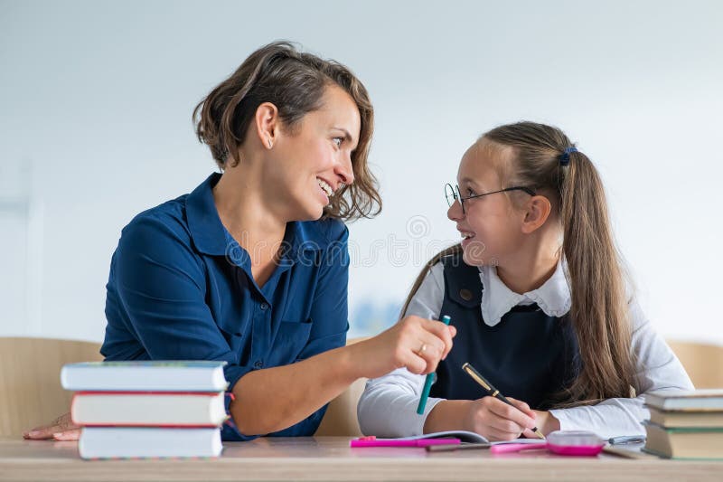 El Profesor Explica La Tarea a La Colegiala En El Aula. Foto de archivo ...