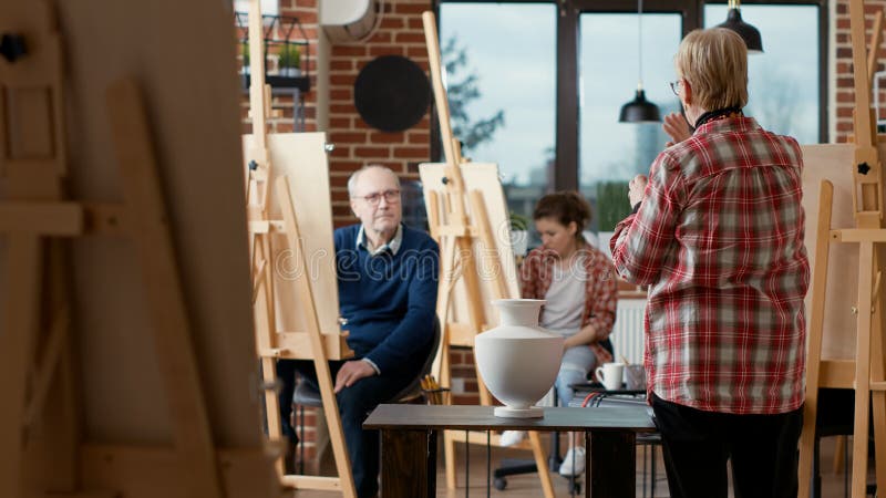 Elder Artist Pointing at Vase on Table To Explain Drawing Technique ...