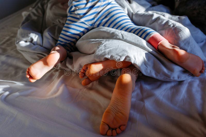 Elder Child and Smaller Child Feet in the Parent& X27;s Bed Under ...
