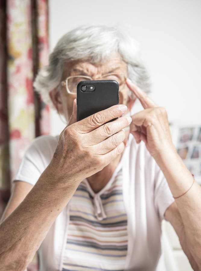An Elder Lady Using a Smartphone Stock Image - Image of face, desk ...