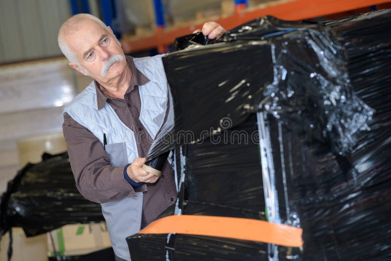 Elder Worker Using Shrink Wrap To Pack Items in Warehouse Stock Image ...