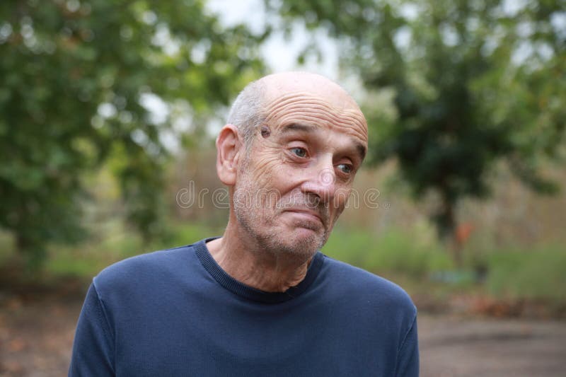 Elderly Man Makes Facial Expression of we Hope Under a Tree in the ...