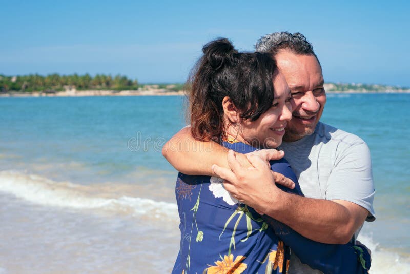 Relaxed and Relaxed Latino Couple Cuddling while Standing on the Beach ...