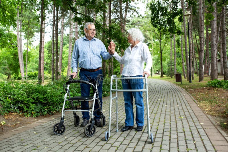 Elderly Couple Holding on To Walking Helper with One Hand Stock Photo ...