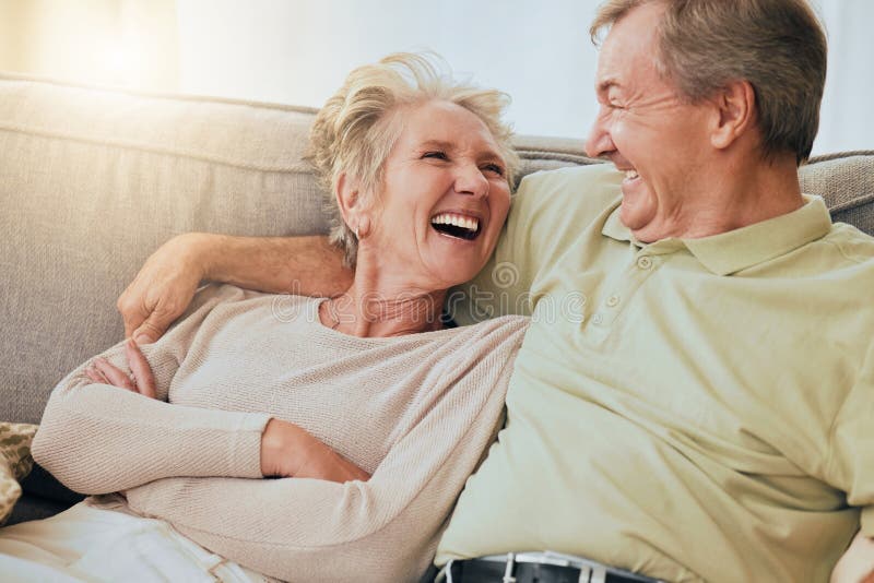 Elderly Couple Laugh And Hug On Sofa In Happy Relationship Silly Face