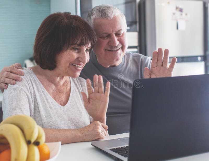 Elderly Couple Looking at Computer in the Kitchen Stock Photo - Image ...