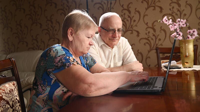 An Elderly Couple is Sitting at a Computer Looking for Information on ...