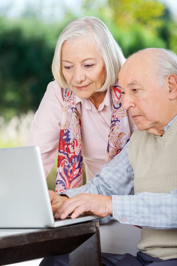 Elderly Couple Using Laptop Stock Photo - Image of help, leisure: 45717102