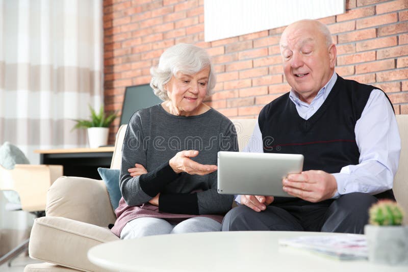 Elderly Couple Using Tablet PC on Sofa Stock Photo - Image of mature ...