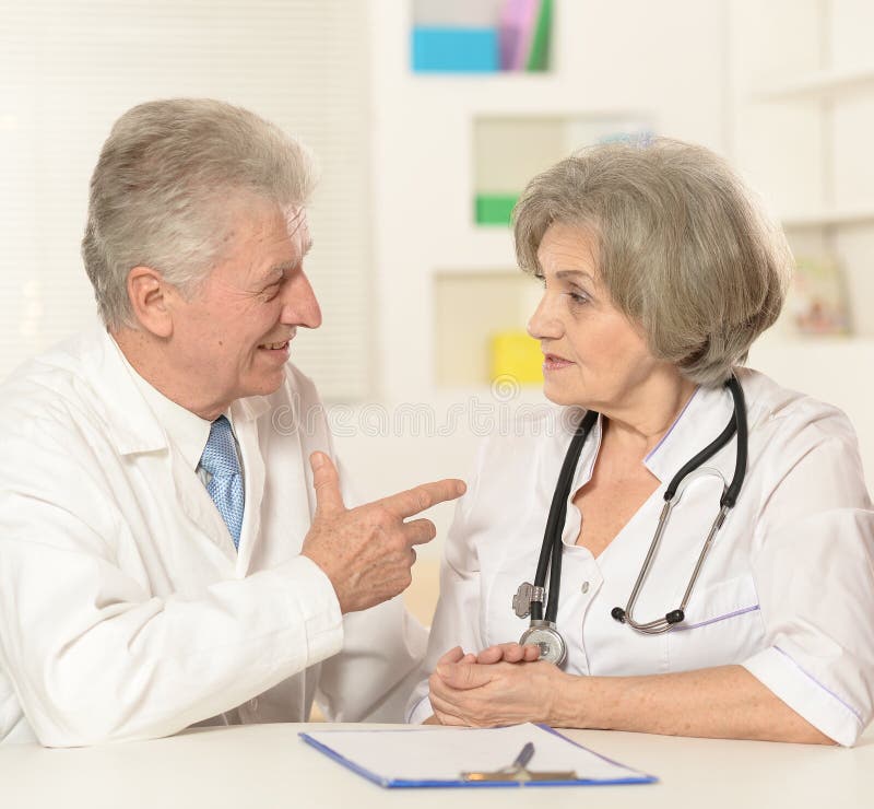 Elderly doctors at table stock photo. Image of portrait - 38193862