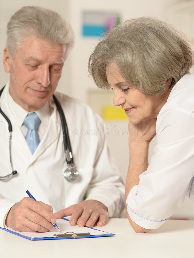Elderly doctors at table stock image. Image of person - 38162331