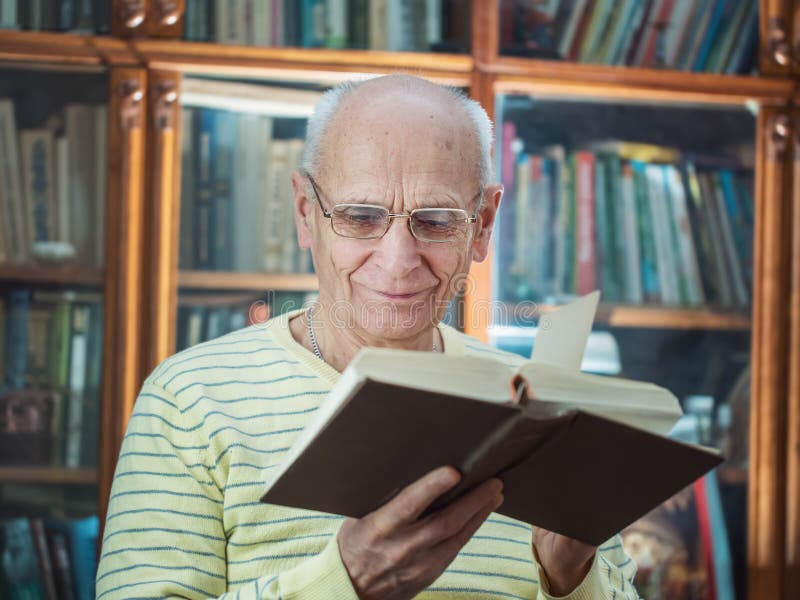 Elderly Intelligent Man Reading Book in His Library at Home in ...
