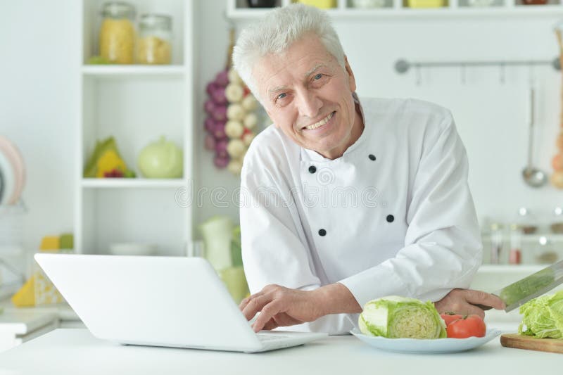 Elderly Male Chef Cooking at Table with Laptop Stock Photo - Image of ...