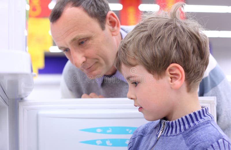 Elderly Man with Boy in Shop Look at Refrigerator Stock Photo - Image ...