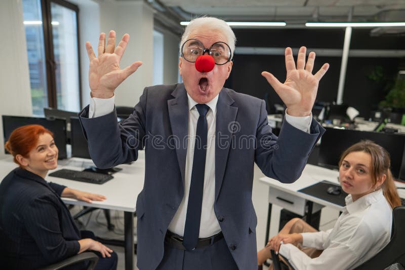 An Elderly Man in a Clown Costume Fools Around at Work. Stock Photo ...
