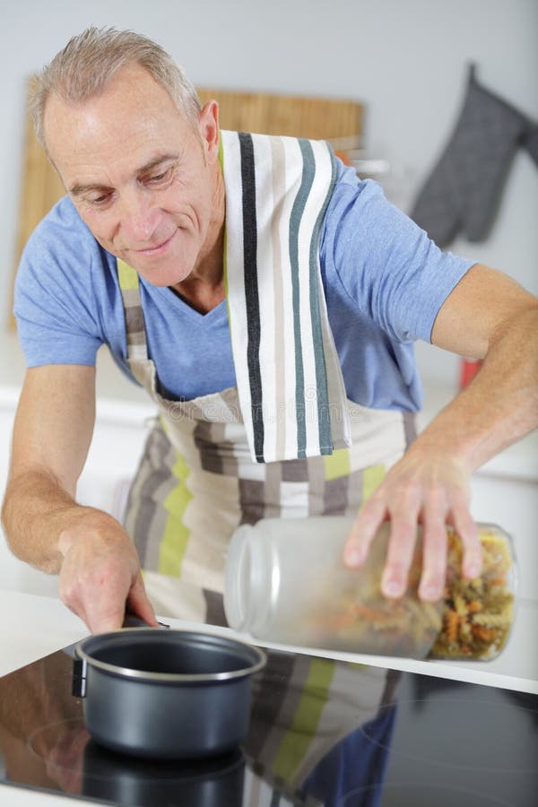 Elderly man cooking pasta stock photo. Image of concept - 160409452