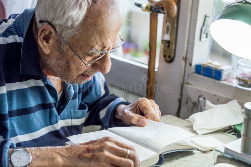 Elderly Man Reading Writings in a Notebook with Magnifying Glass Near ...