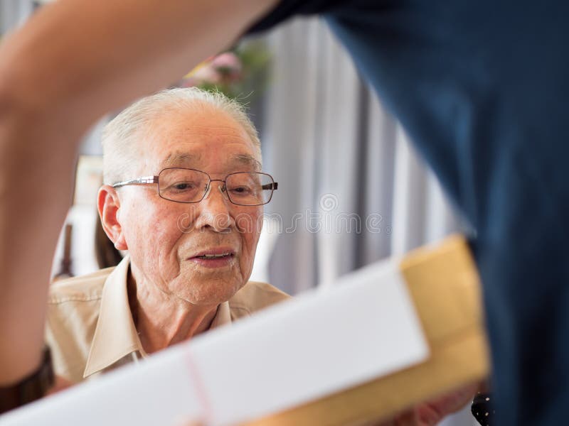 An Elderly Man Looking at Something he is Receiving with Great Interest ...
