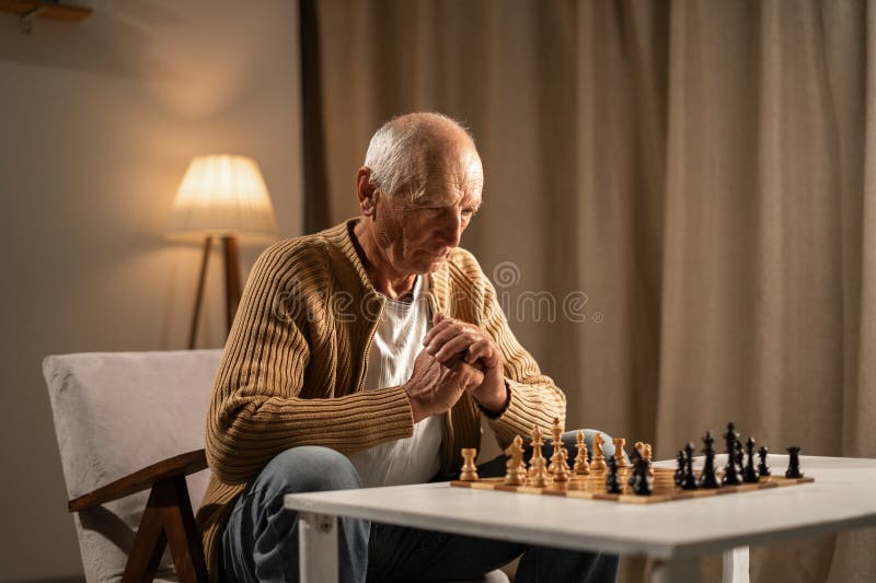 Elderly Man Playing Chess Alone Sitting at Home in a Cozy Room in the ...