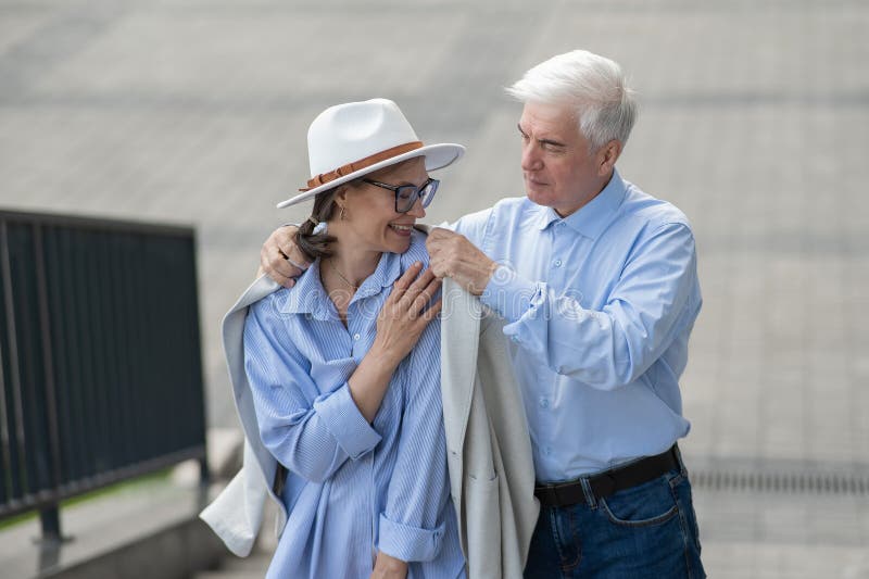 An Elderly Man Puts His Jacket on a Woman. Romantic Relationships of ...