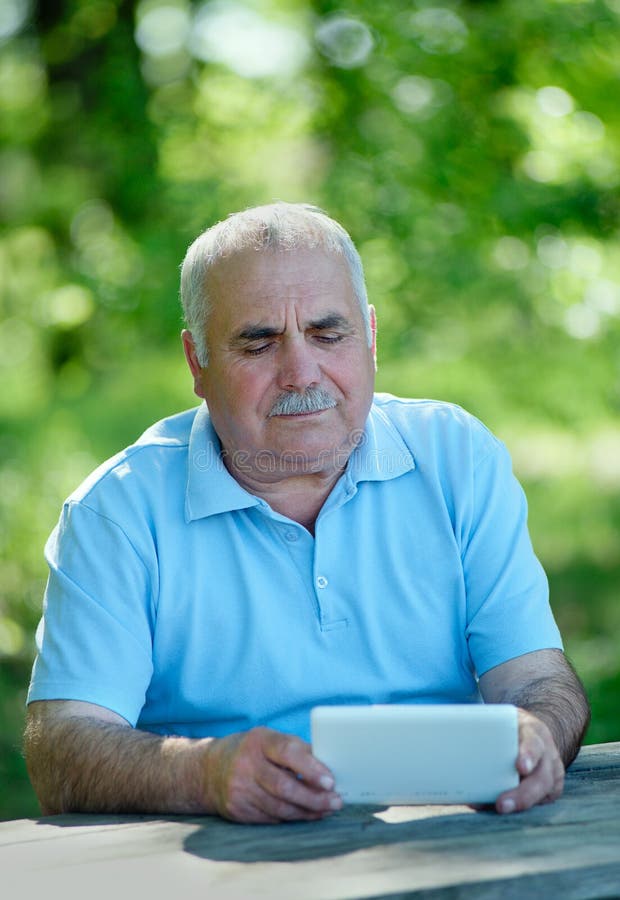 Elderly Man Reading on a Tablet Computer Stock Photo - Image of ...