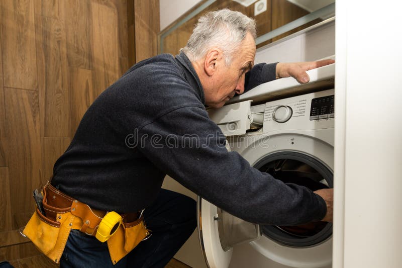 An Elderly Man Repairs a Washing Machine. Stock Photo - Image of male ...