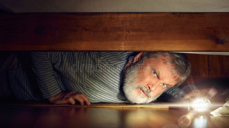 Elderly Man with Serious and Curious Face Looking Under Bed with ...