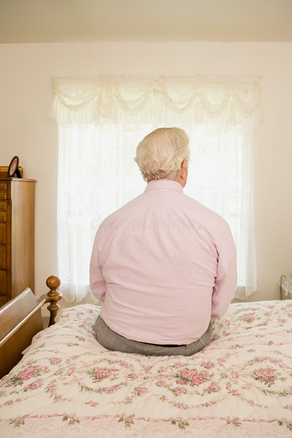 Elderly man sitting on bed stock photo. Image of experience - 62809300