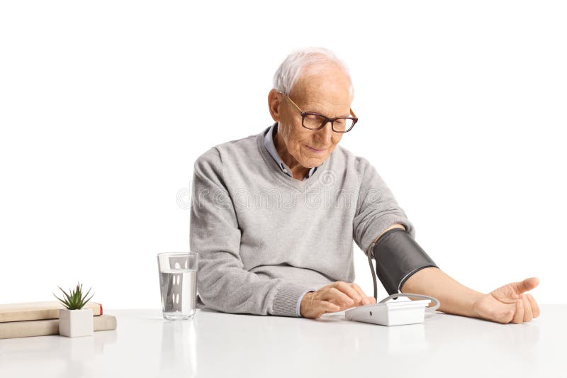 Elderly Man Sitting at a Table and Checking Blood Pressure with a ...