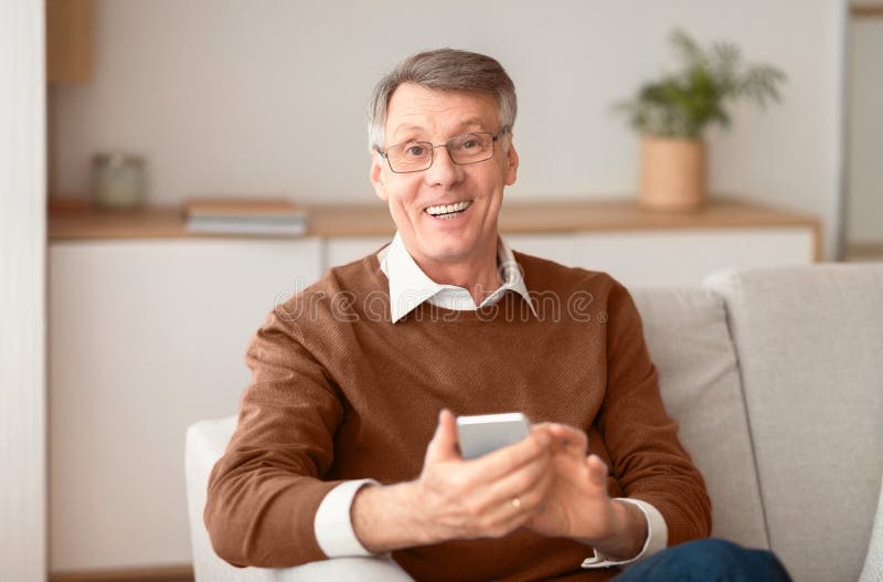 Elderly Man Using Smatphone Smiling Sitting on Sofa Indoor Stock Image ...