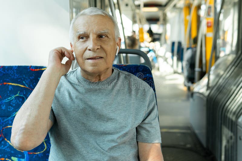 Elderly Man is Using Wireless Earbuds during Ride in Public Transport ...