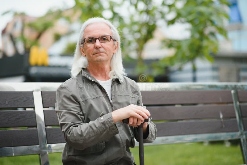 Elderly Man Walks With A Cane In A City Spring Park Stock Image