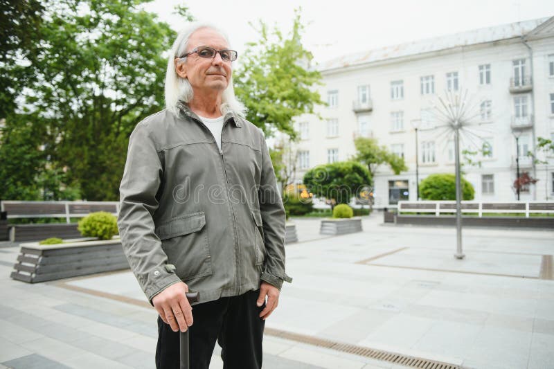 Elderly Man Walks With A Cane In A City Spring Park Stock Image