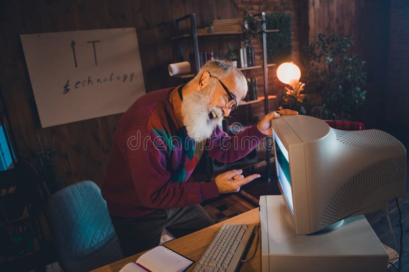 Elderly Man Working with Vintage Computer in a Cozy Office at Night ...
