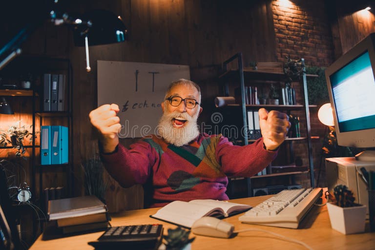 Elderly Programmer Engaged in Remote Work Using a Desktop Computer in a ...