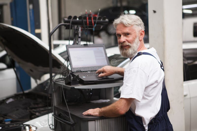 Elderly Repairman Working on a Car Stock Image - Image of laptop ...