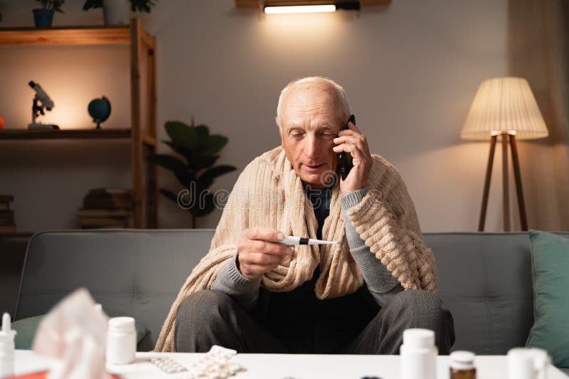 Elderly Sick Man Sitting on Couch, Checking Temperature with ...