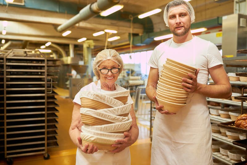 Elderly Woman As Baker and Young Apprentice with Bread Baskets Stock ...