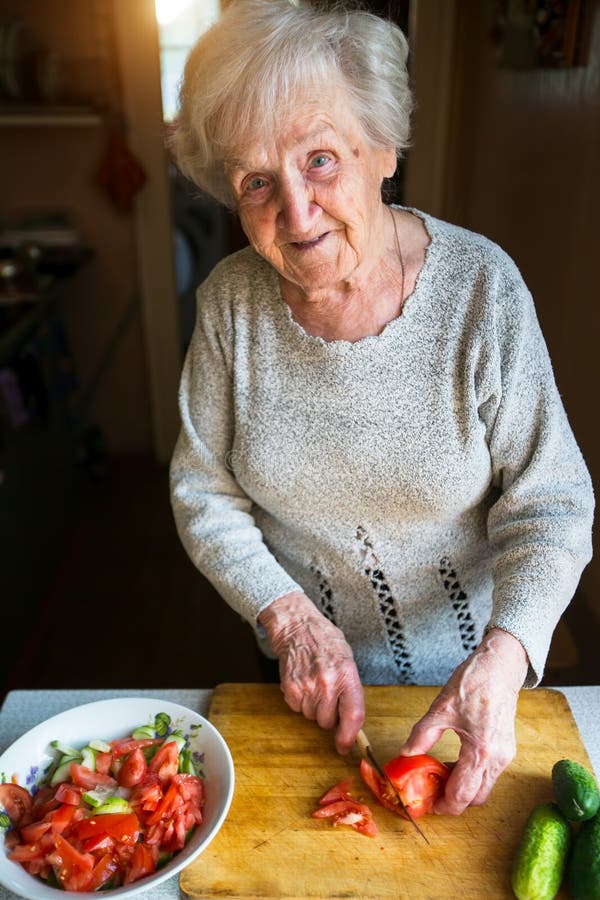 An Elderly Woman Chops Vegetables for a Salad. Vegetable. Stock Image ...