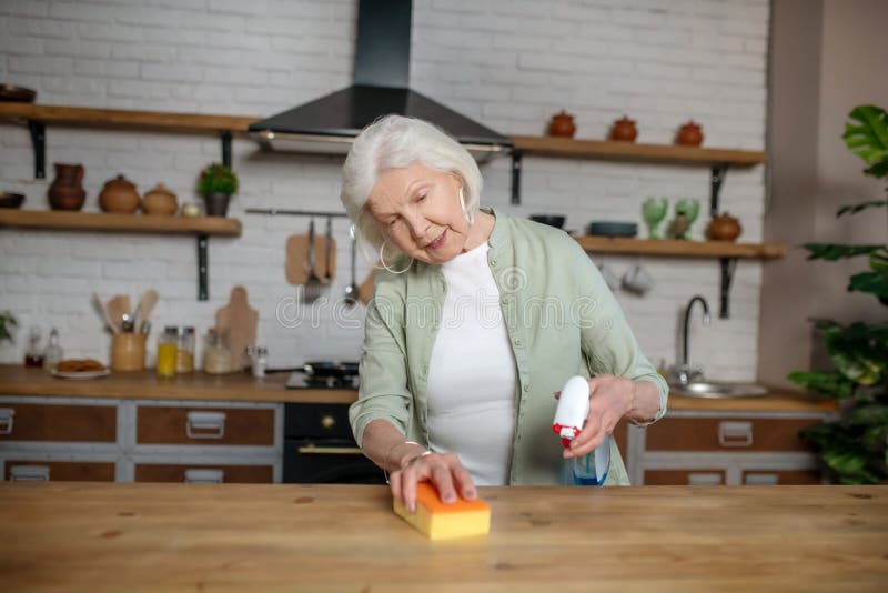 Elderly Woman Cleaning a Table in Her Kitchen Stock Photo - Image of ...
