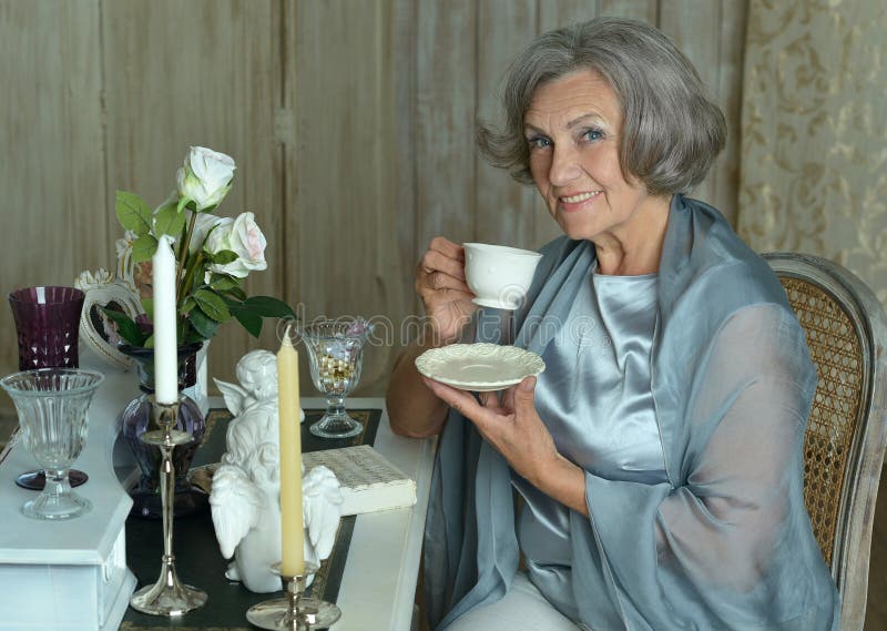 Elderly woman drinking tea stock image. Image of house - 44062705