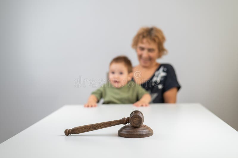 An Elderly Woman Holds a Child Behind a Judge& X27;s Gavel. Stock Photo ... An Elderly Woman Holds a Child Behind a Judge& X27;s Gavel. Stock Photo ...
